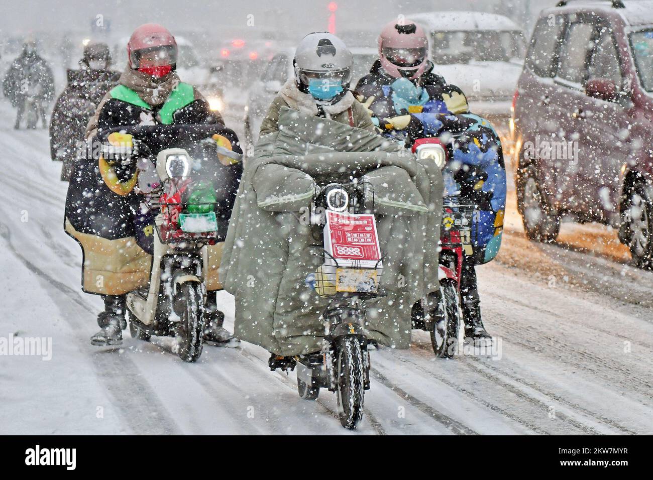 YANTAI, CHINA - NOVEMBER 17, 2022 - People brave snow on a street in ...