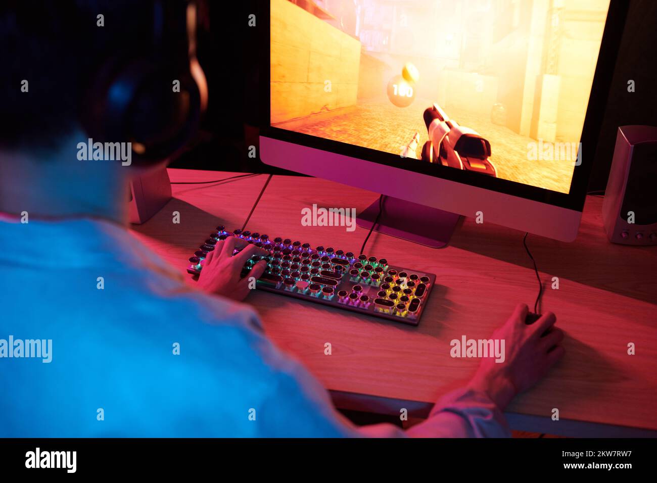 Teenage boy playing first person shooter videogame, view over the ...