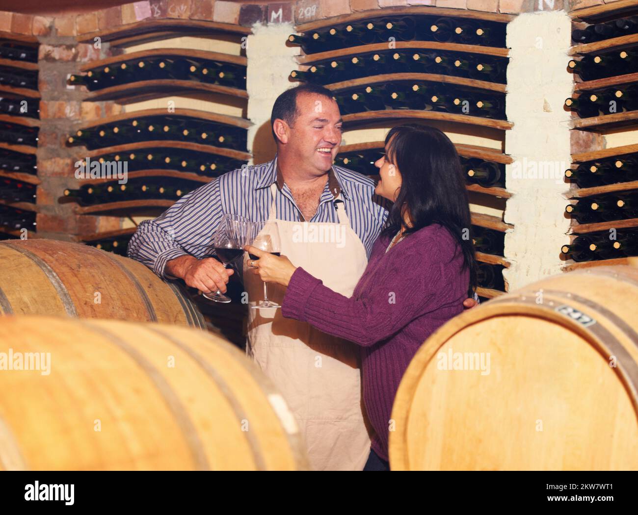 They make beautiful wines together. A mature wine maker toasting with ...