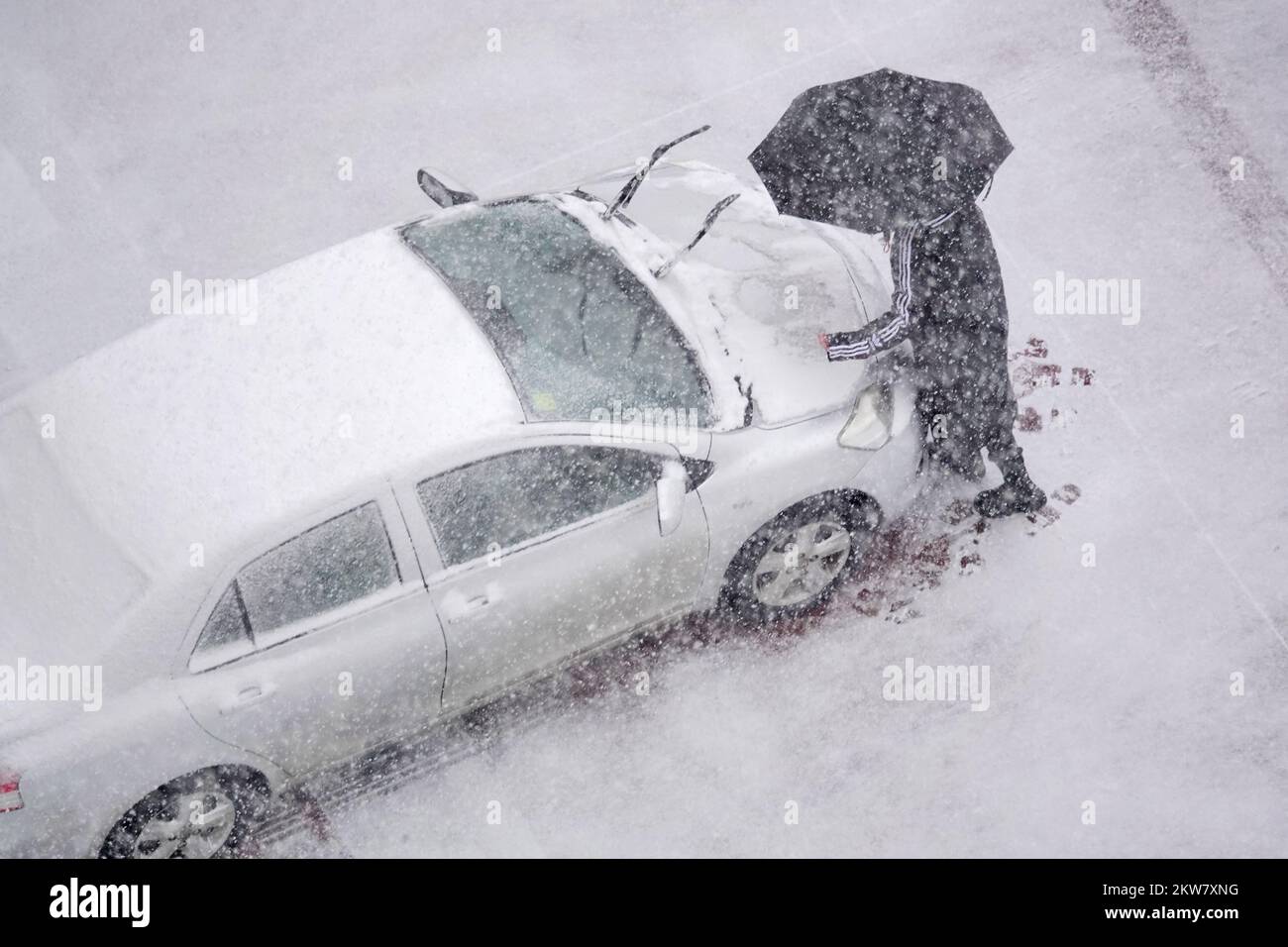 YANTAI, CHINA - NOVEMBER 17, 2022 - People check the snow on a car in ...