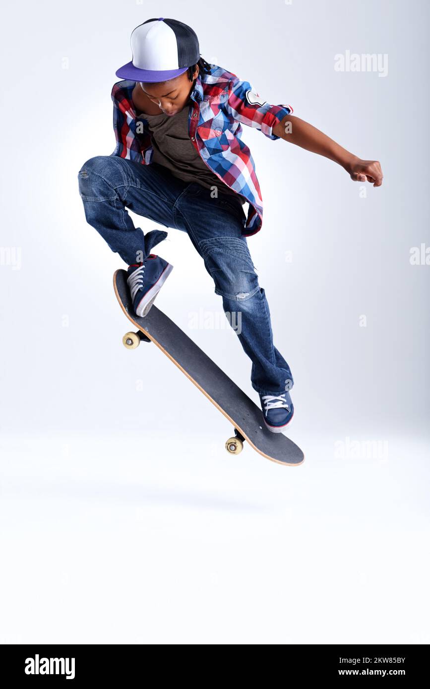 Mad skills. An African-American boy doing a trick on his skateboard ...