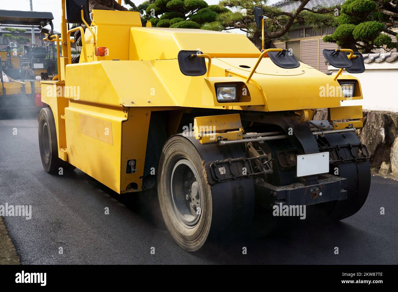 Pneumatic roller of tires compacting new asphalt of a street. Repaving ...