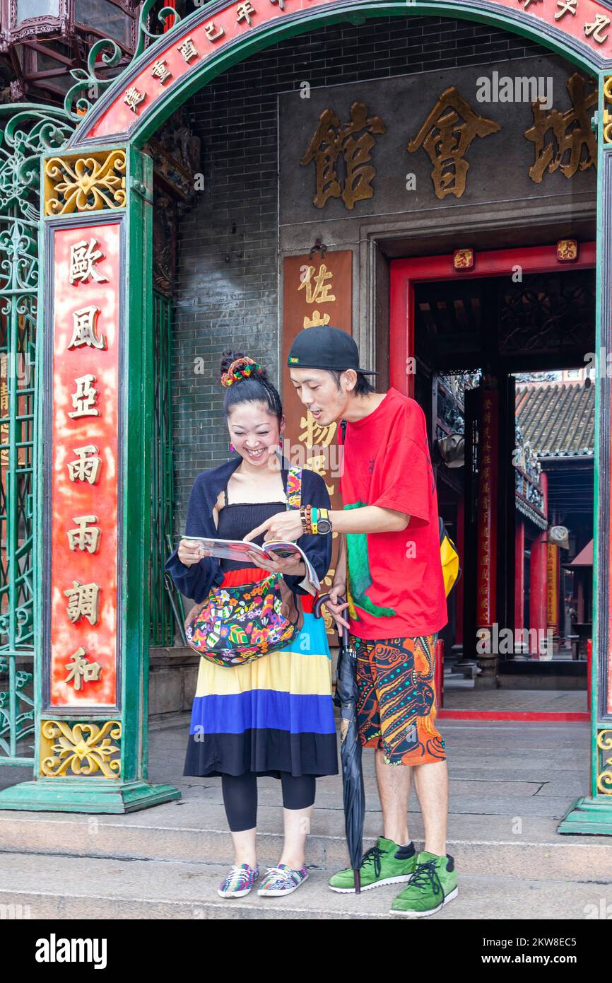 Asian tourist couple reading tour guide book, Hoi Quan Tue Thanh temple ...