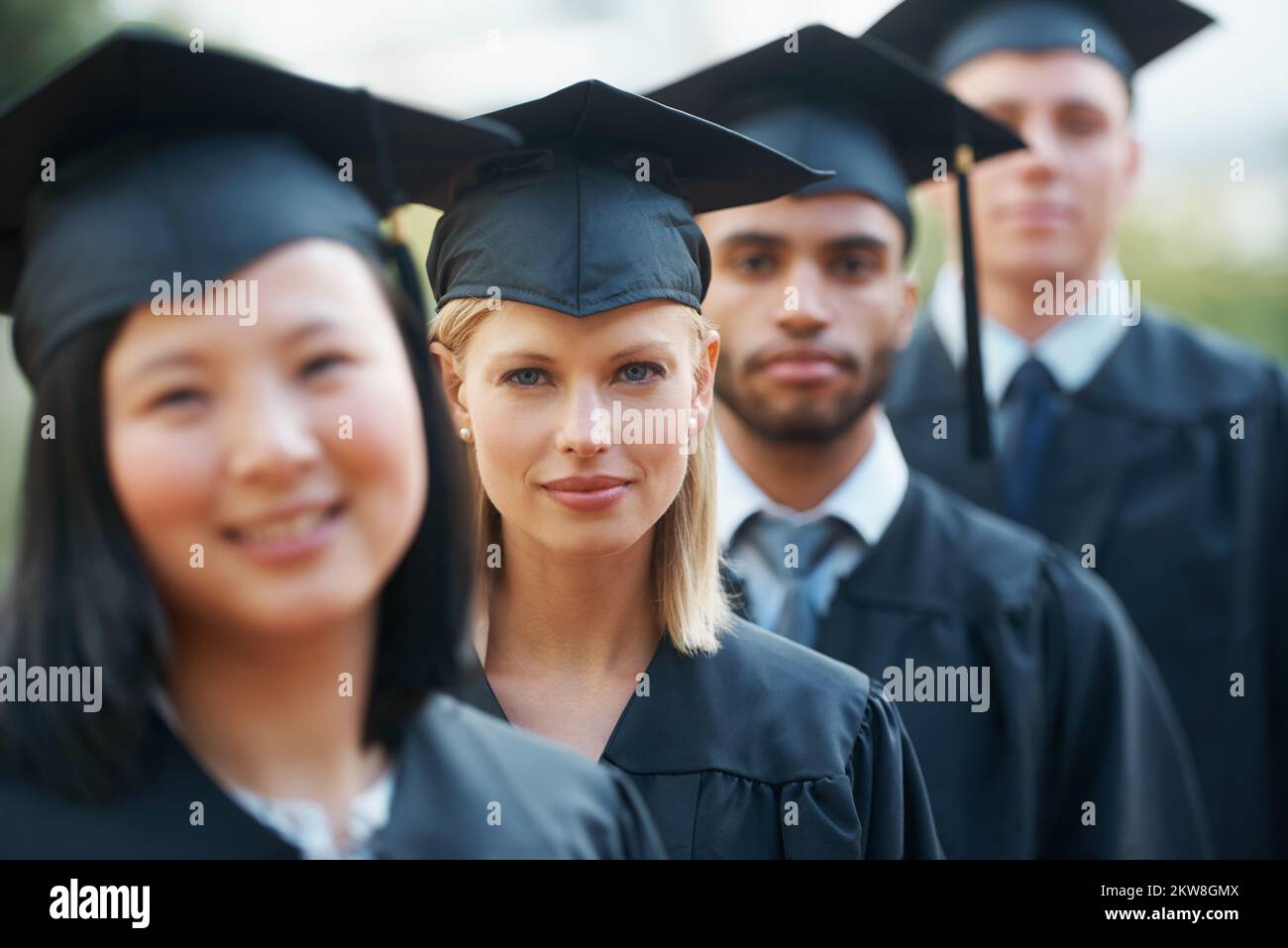 Ready for the real world. Young college graduates holding their ...