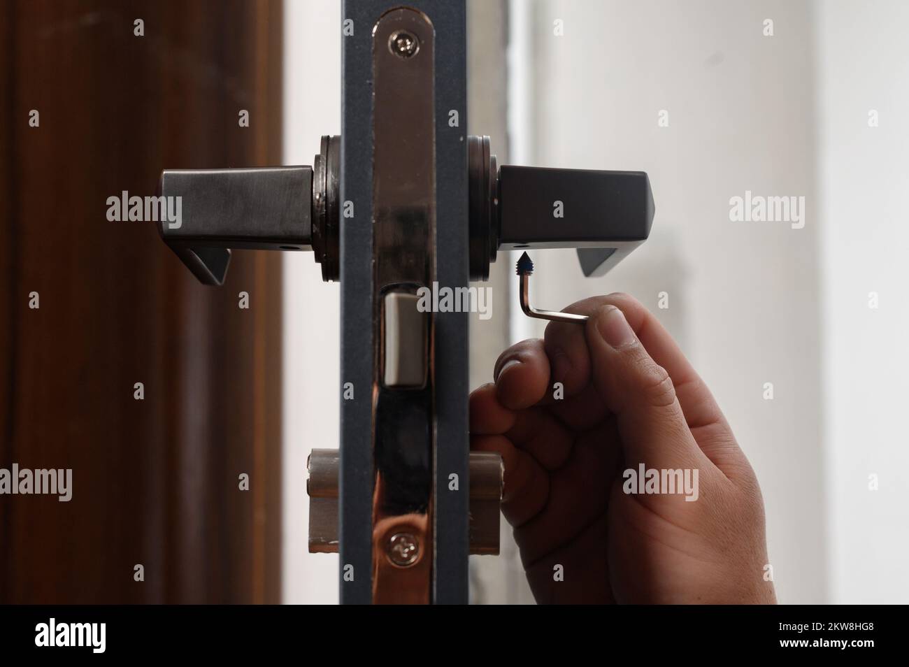 The craftsman installs the door handle with the help of a sprocket key ...