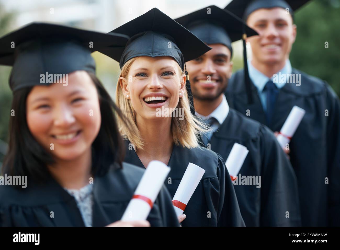 Thrilled to be graduates. Young college graduates holding their ...