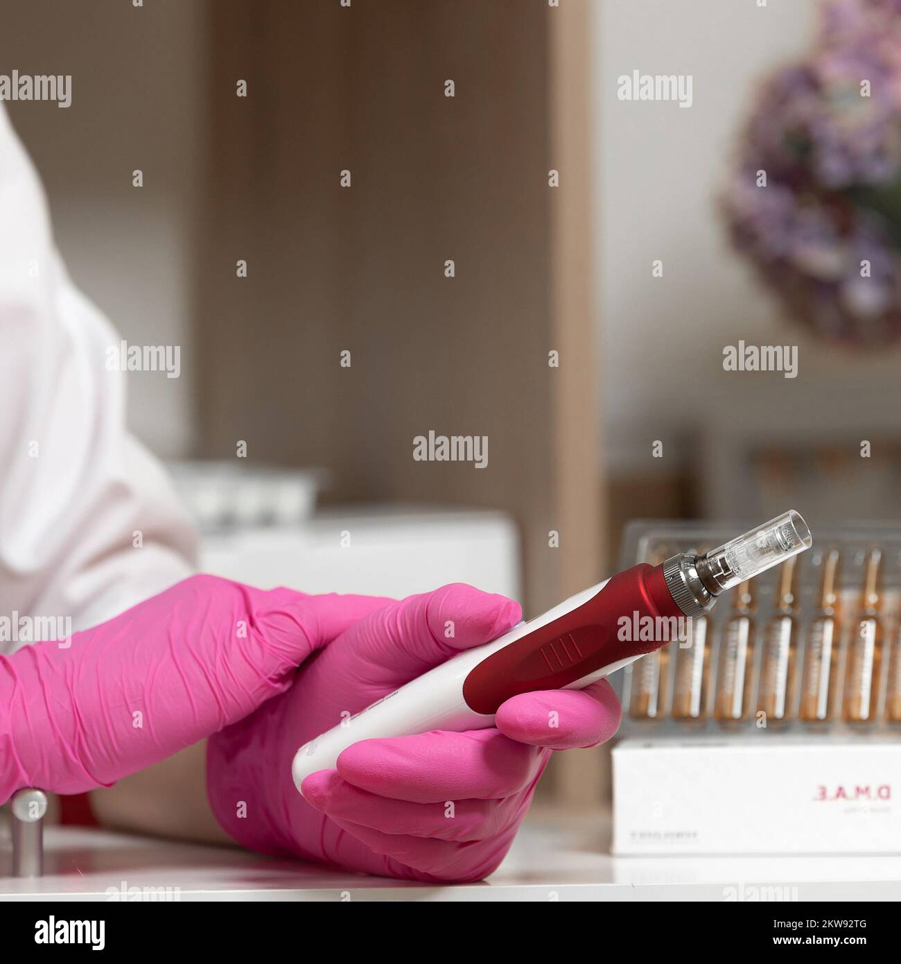 The cosmetologist holds in his hands a dermapen, a tool for mesotherapy ...