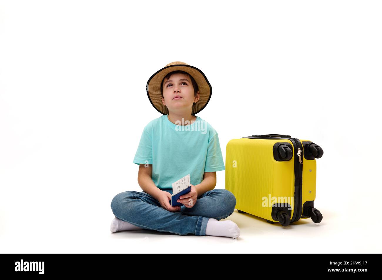 Multi-ethnic teenage traveler boy in straw hat with suitcase and ...
