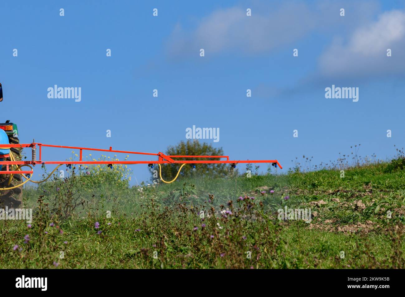A tractor with a tank and attached equipment for spraying the field ...