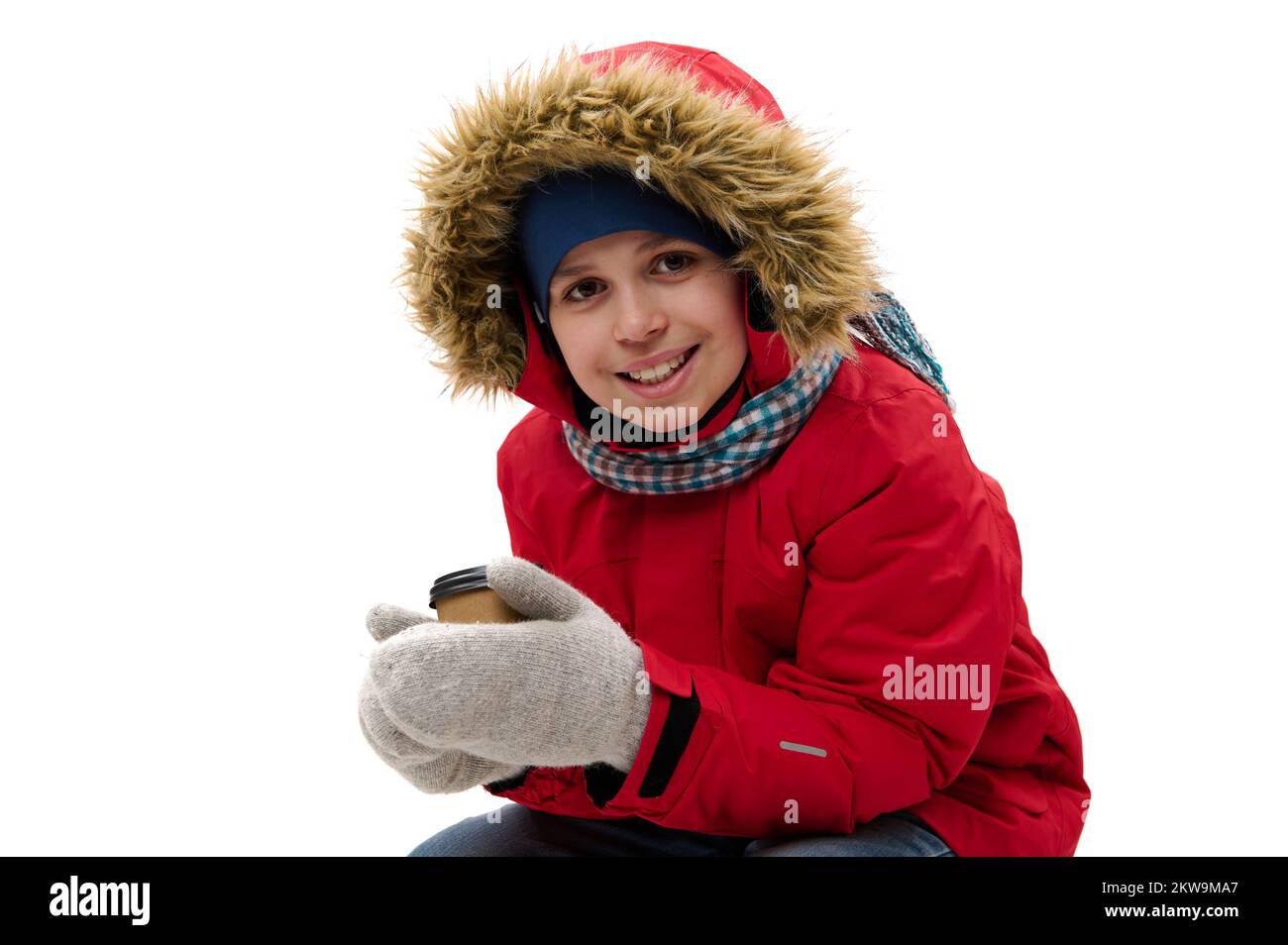Adorable multi-ethnic teenage boy in red parka, holds a paper mug of ...
