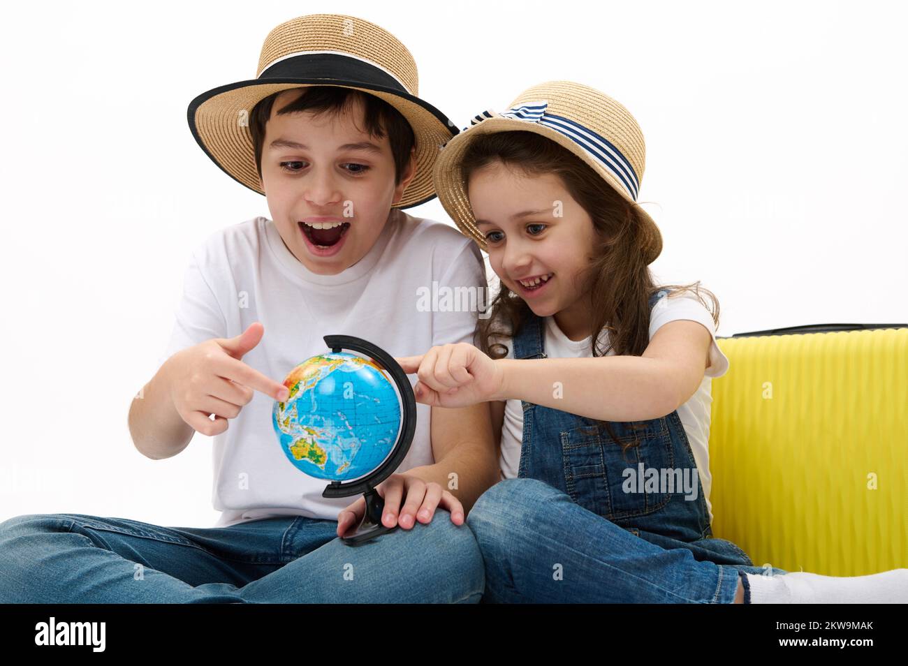 Happy children, boy and girl with yellow suitcase, choose a place to ...