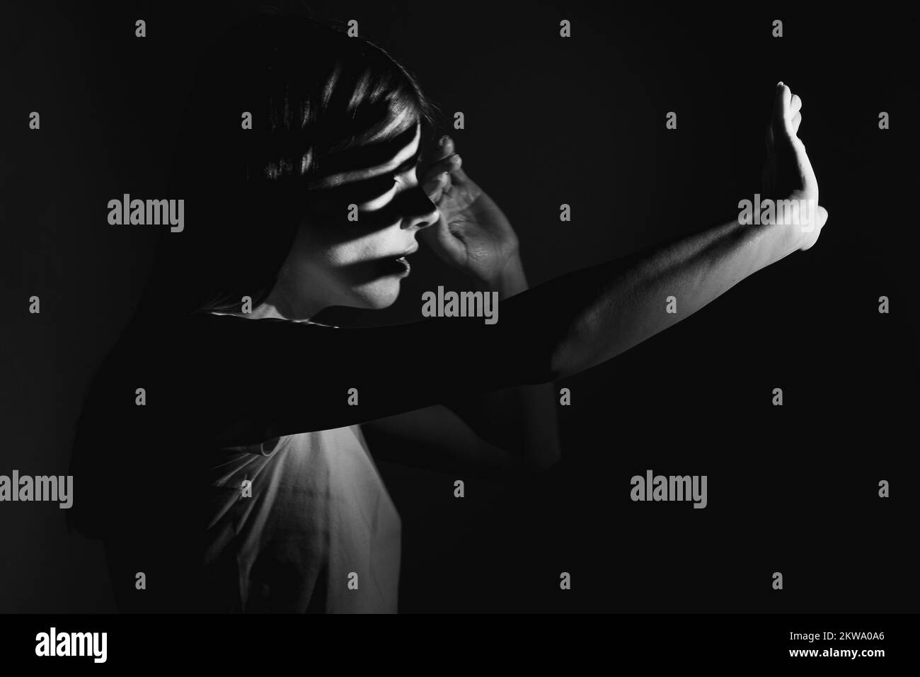 The girl covers her face with her hands from the bright light in the ...