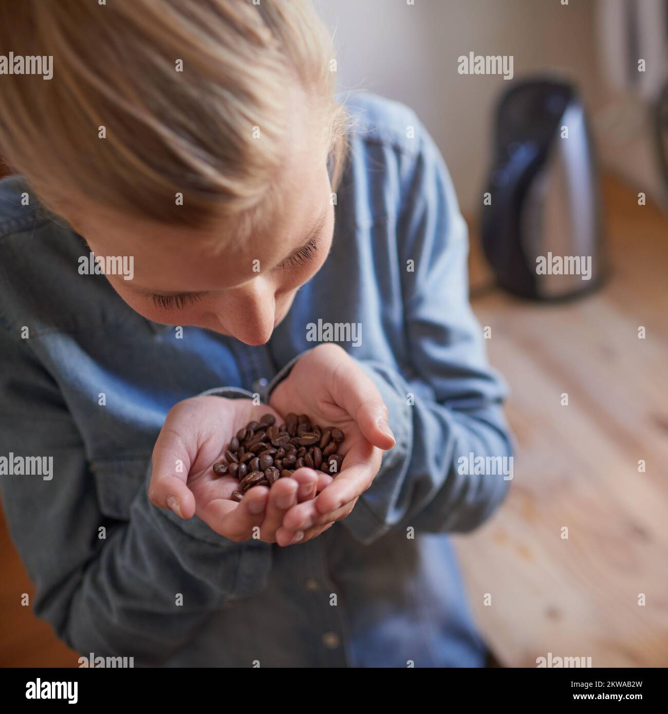 Fresh aroma of coffee beans. A young woman smelling fresh coffee beans ...