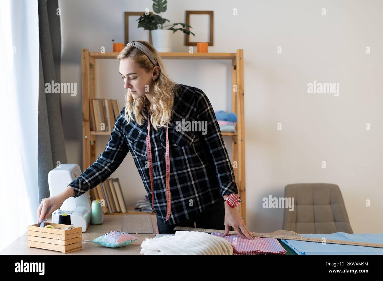 tailor woman working on clothes in tailoring atelier. young female ...