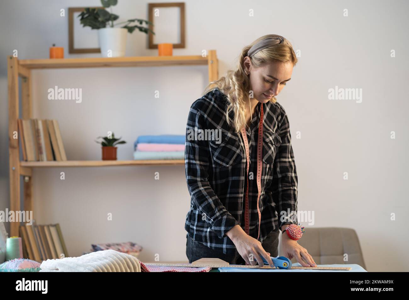 Dressmaker cutting dress fabric on sketch line with sewing knife ...