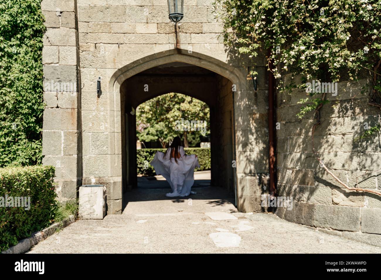 a beautiful woman in a white dress walks through a beautiful palace on ...