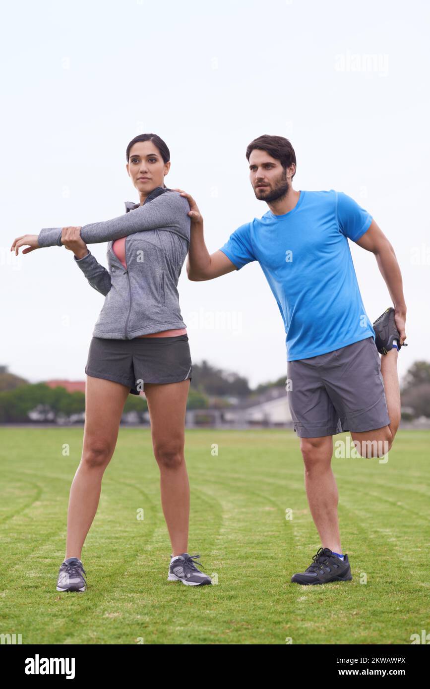 Getting ready to burn coms cals. two people helping each other stretch ...