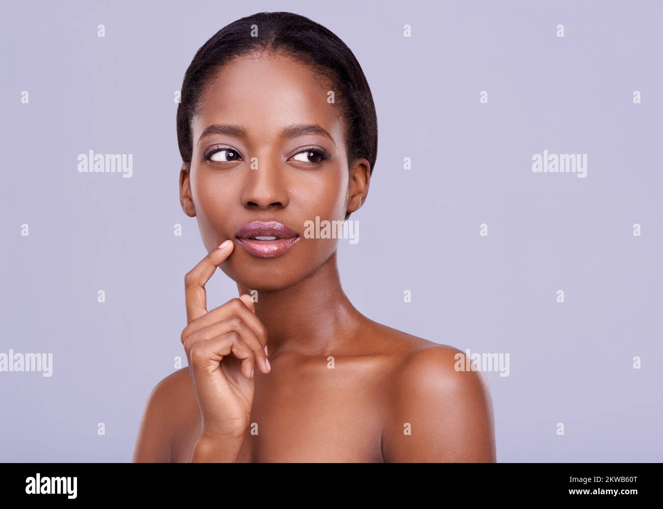 Taking care of her skin. an attractive young woman touching her skin ...