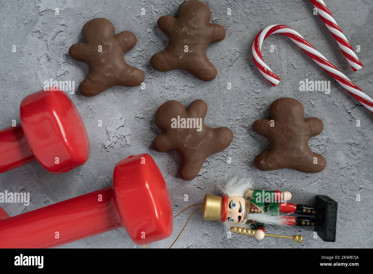 Chocolate gingerbread man cookies, gym dumbbells, Christmas nutcracker figure, candy canes ...