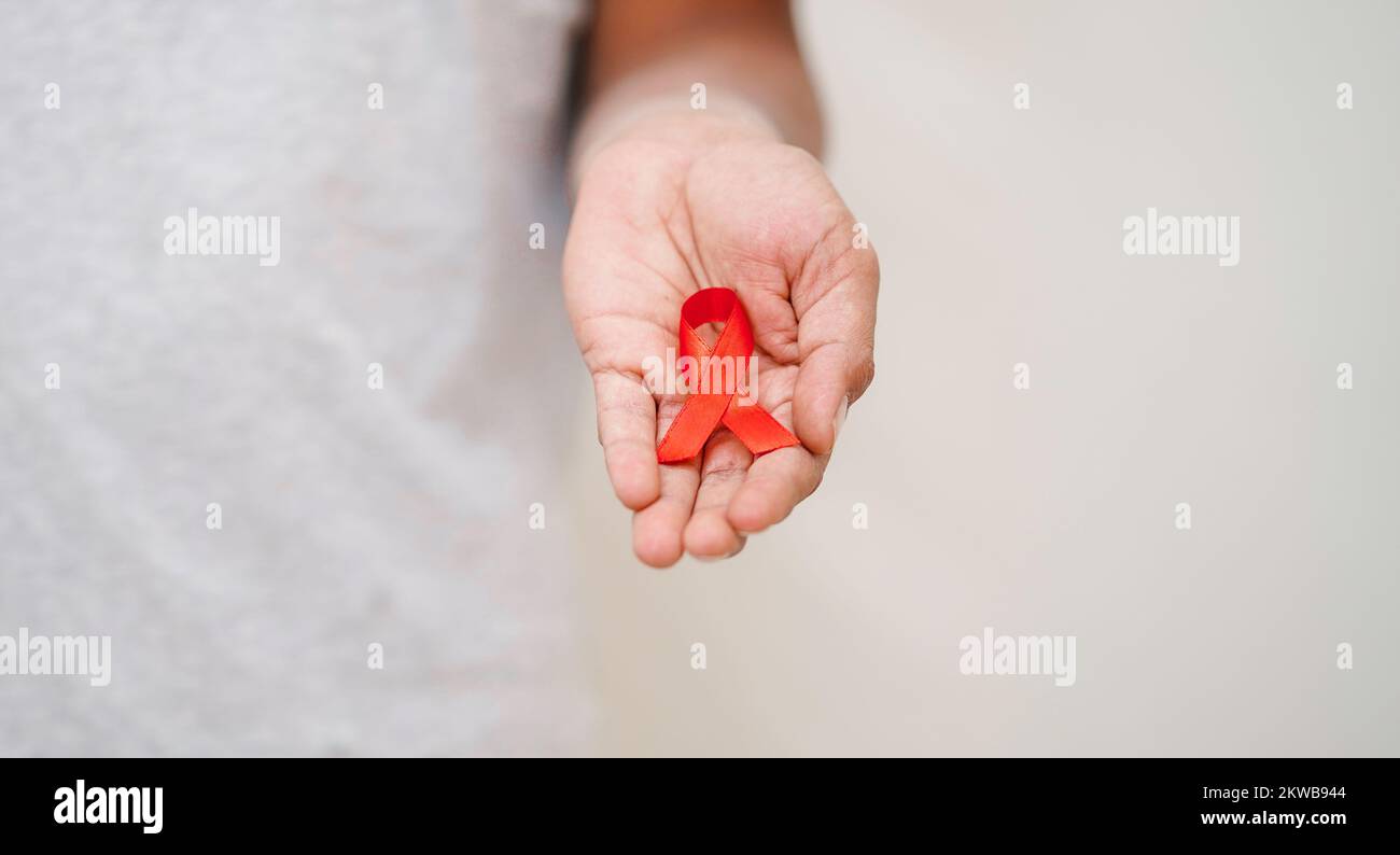 female hand with red aids awareness ribbon, HIV AIDS Badge to spread ...