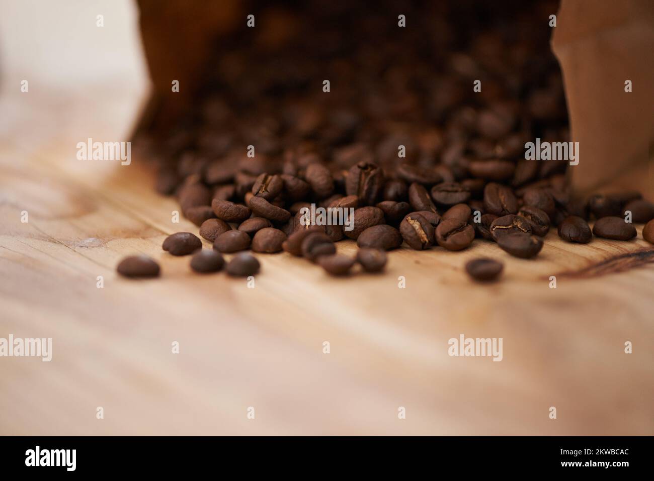The joys of fresh coffee. roasted coffee beans spilling out from a bag on a counter Stock Photo ...