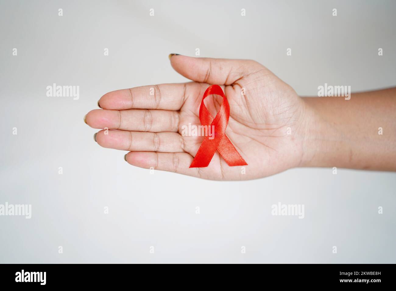 A women holding red ribbon in one hand representing Worlds HIV Aids Day ...