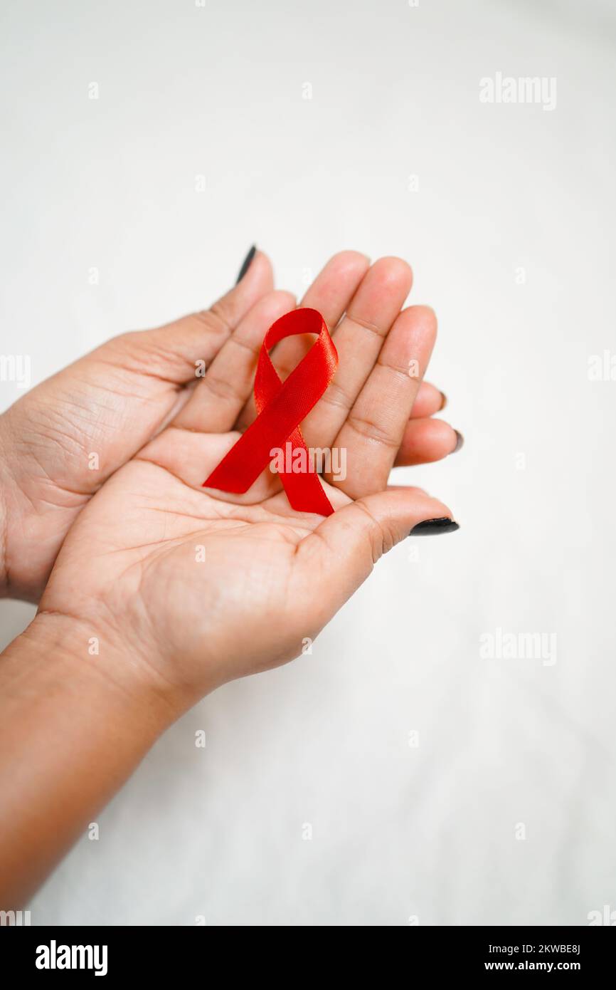 Worlds HIV Aids Day 2022-2023, Closeup hands holding red aids awareness ribbon on white ...