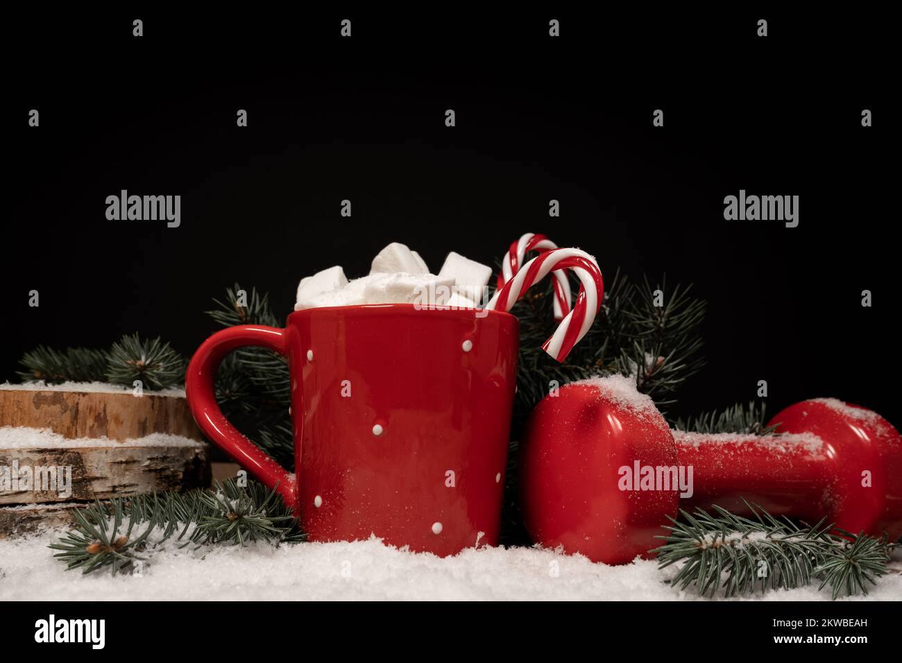 Hot chocolate or cocoa with marshmallows and candy canes, dumbbell on ...