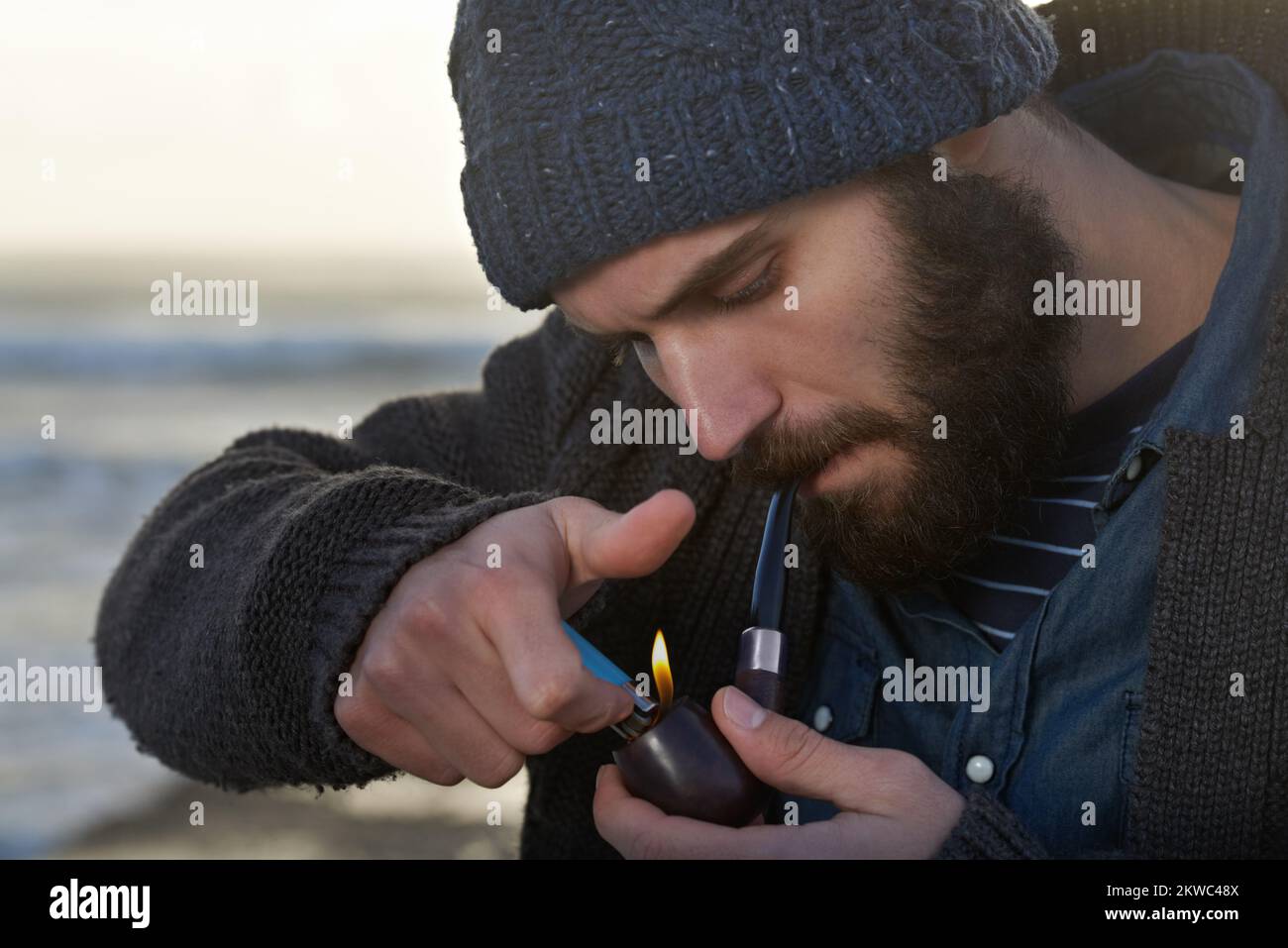 Smoking a pipe. a bearded man smoking a pipe outside Stock Photo - Alamy