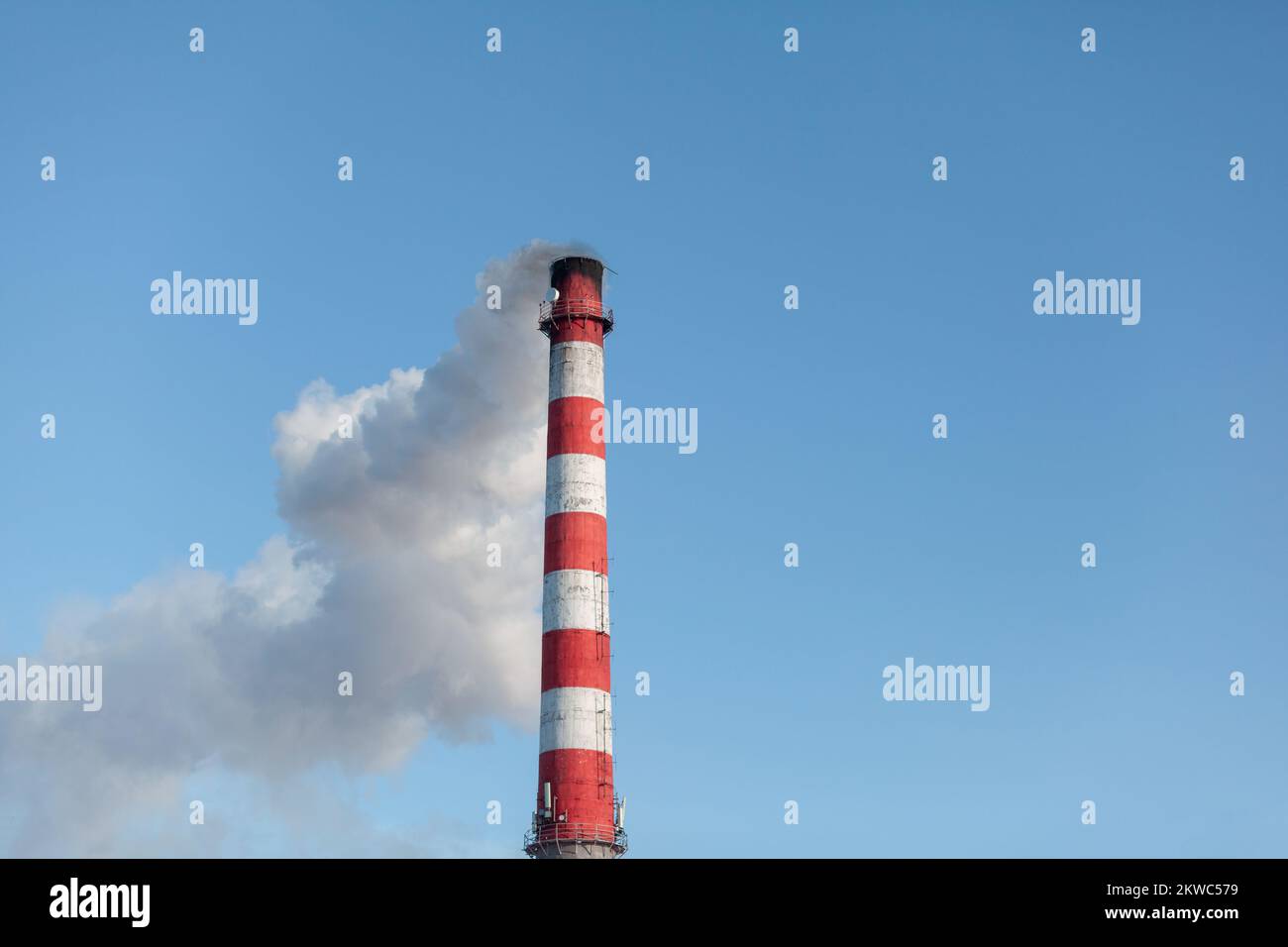 White thick smoke from the boiler room chimney. Smoke against the blue ...