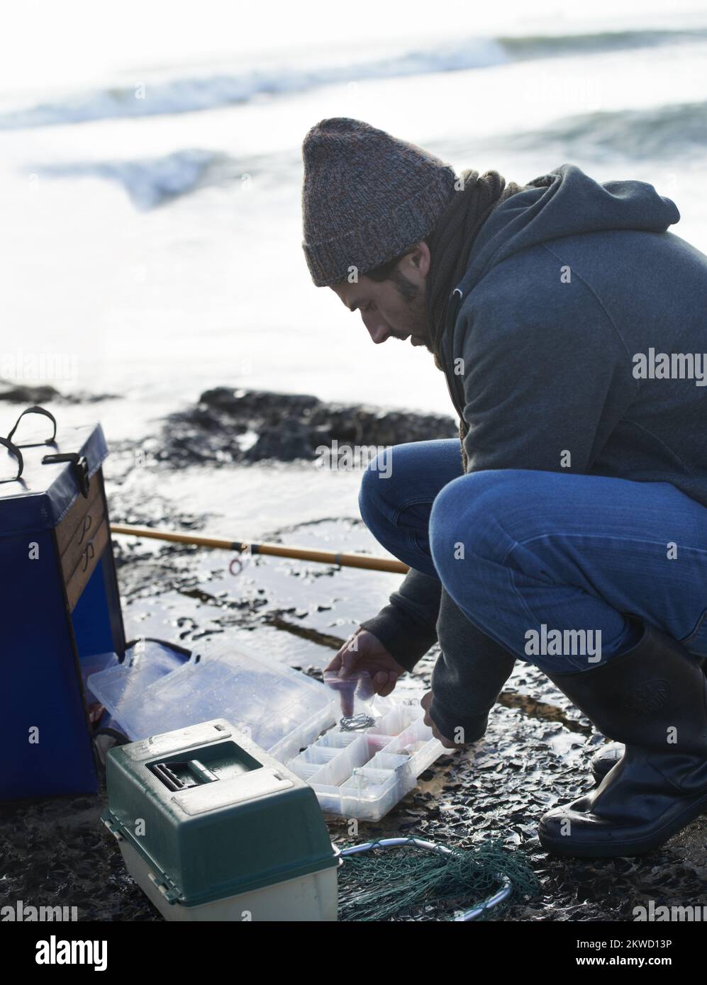Choosing the right tackle. a young fisherman preparing his rod and ...