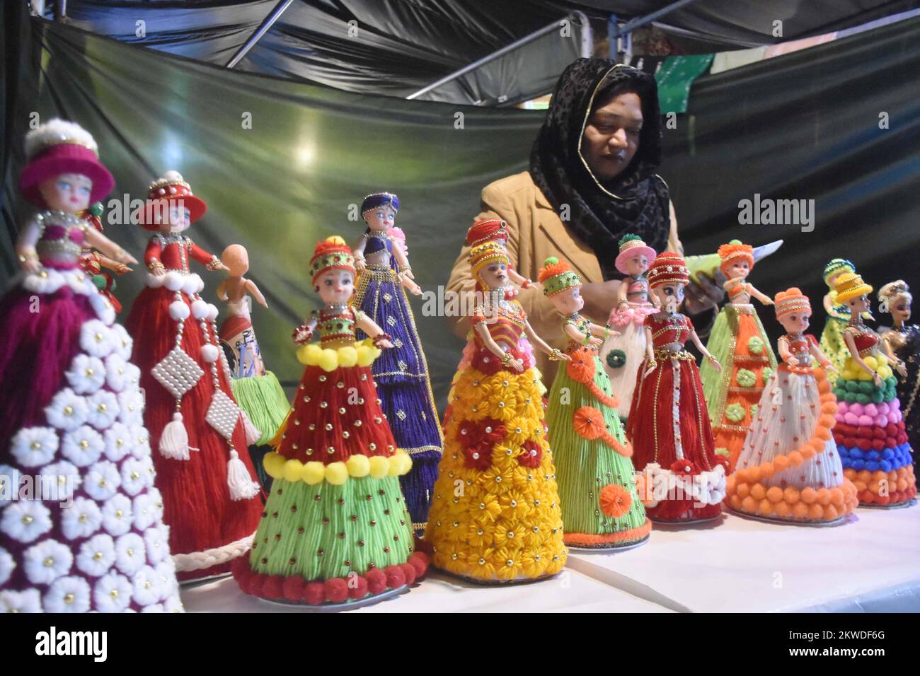 Islamabad. 29th Nov, 2022. A woman displays dolls at the Lok Mela ...