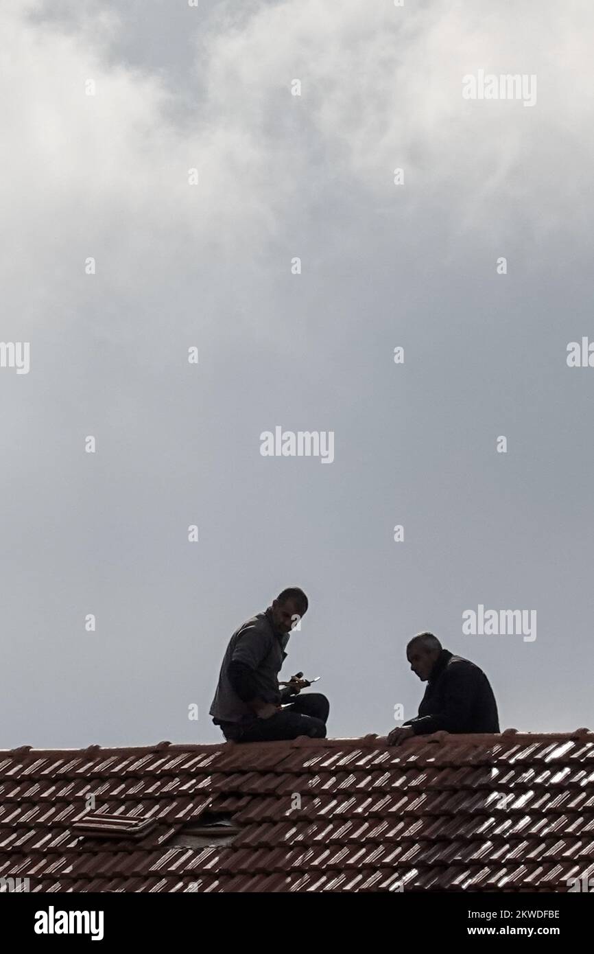 Men work on a rooftop Stock Photo - Alamy