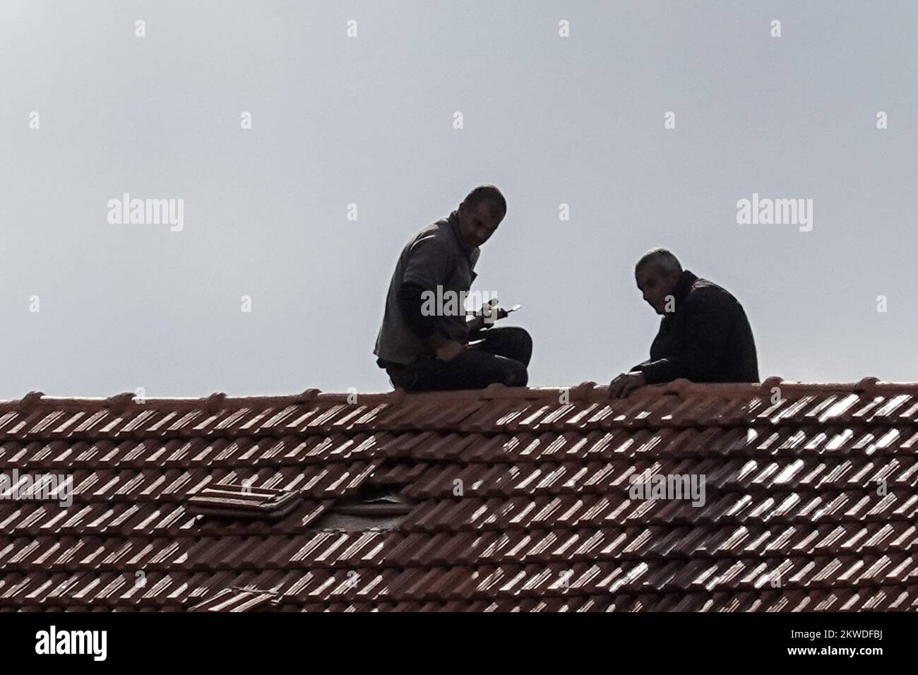 Men work on a rooftop Stock Photo - Alamy