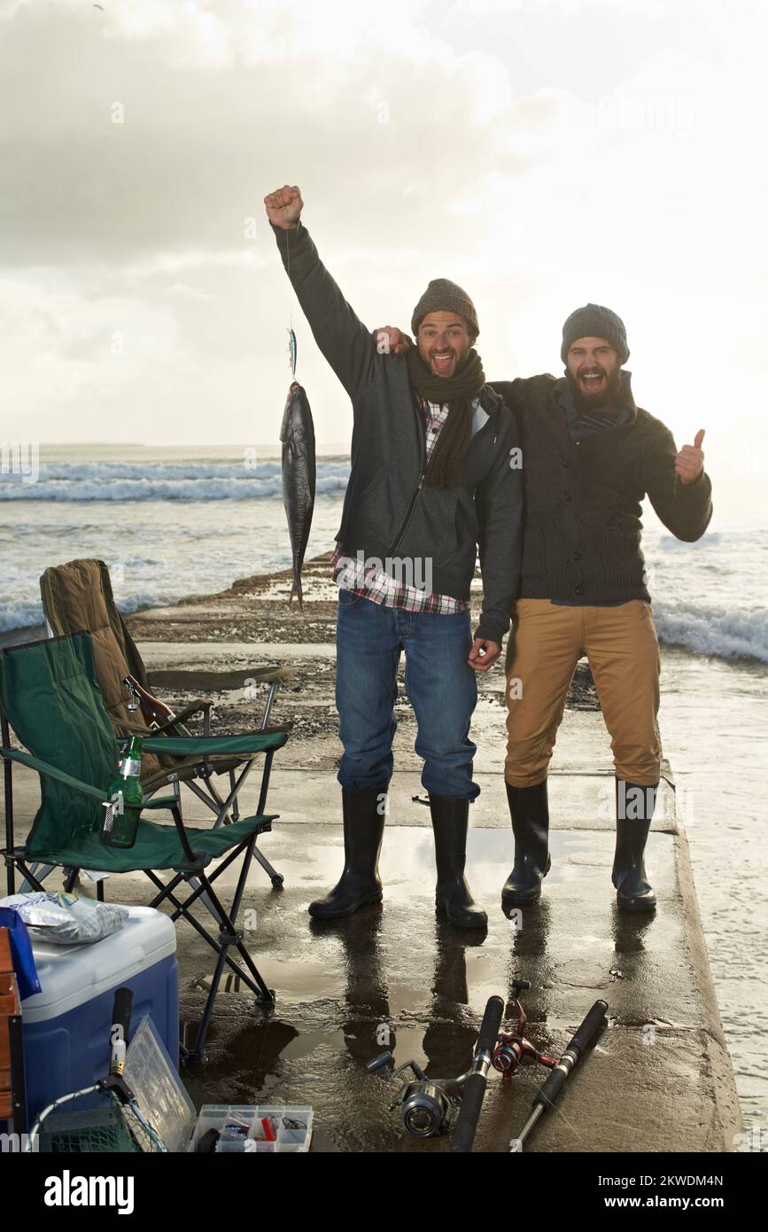 He fought hard, but I won in the end. two young men fishing off a pier ...