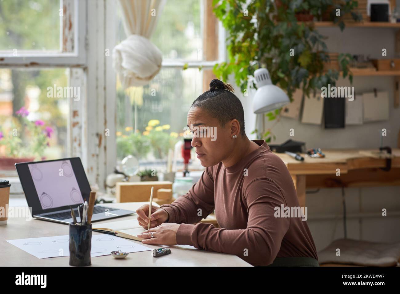 Side view portrait of modern female artist working on new designs in ...
