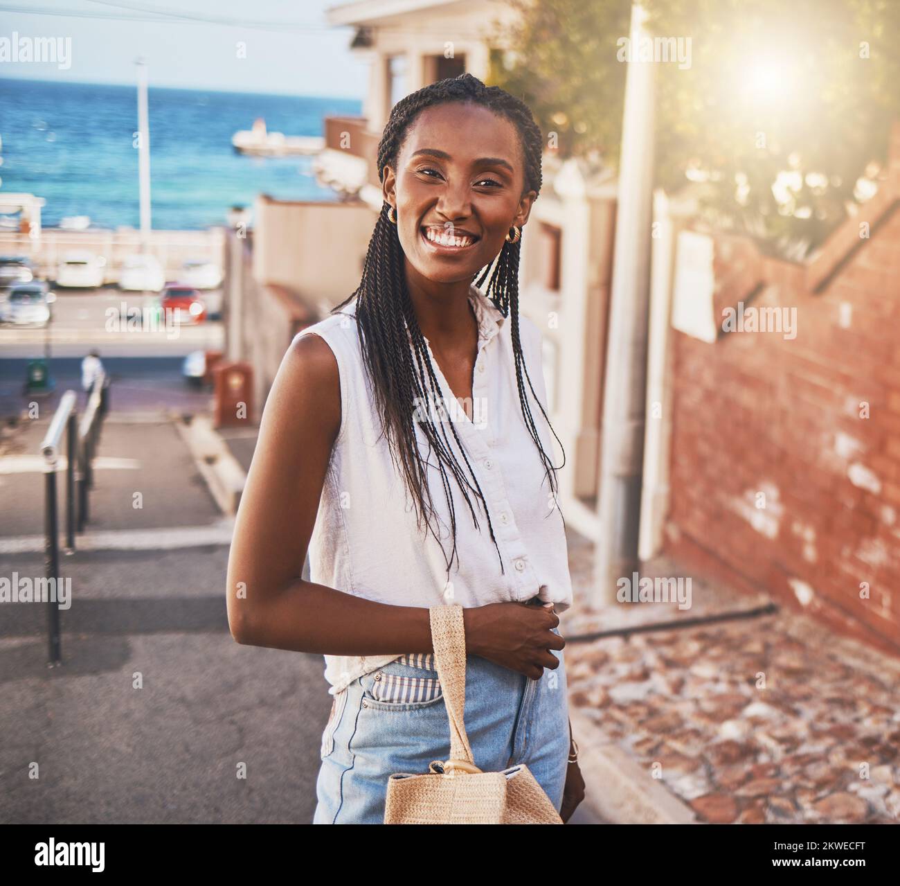 Happy smile black woman on vacation in city by sea or ocean water port ...