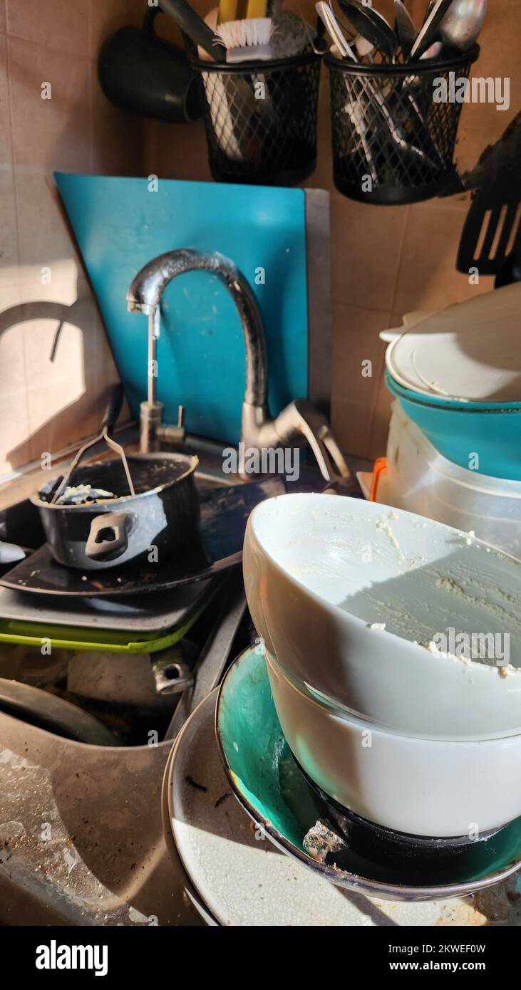 A mess in the kitchen. Dirty dishes around the sink. The concept of ...