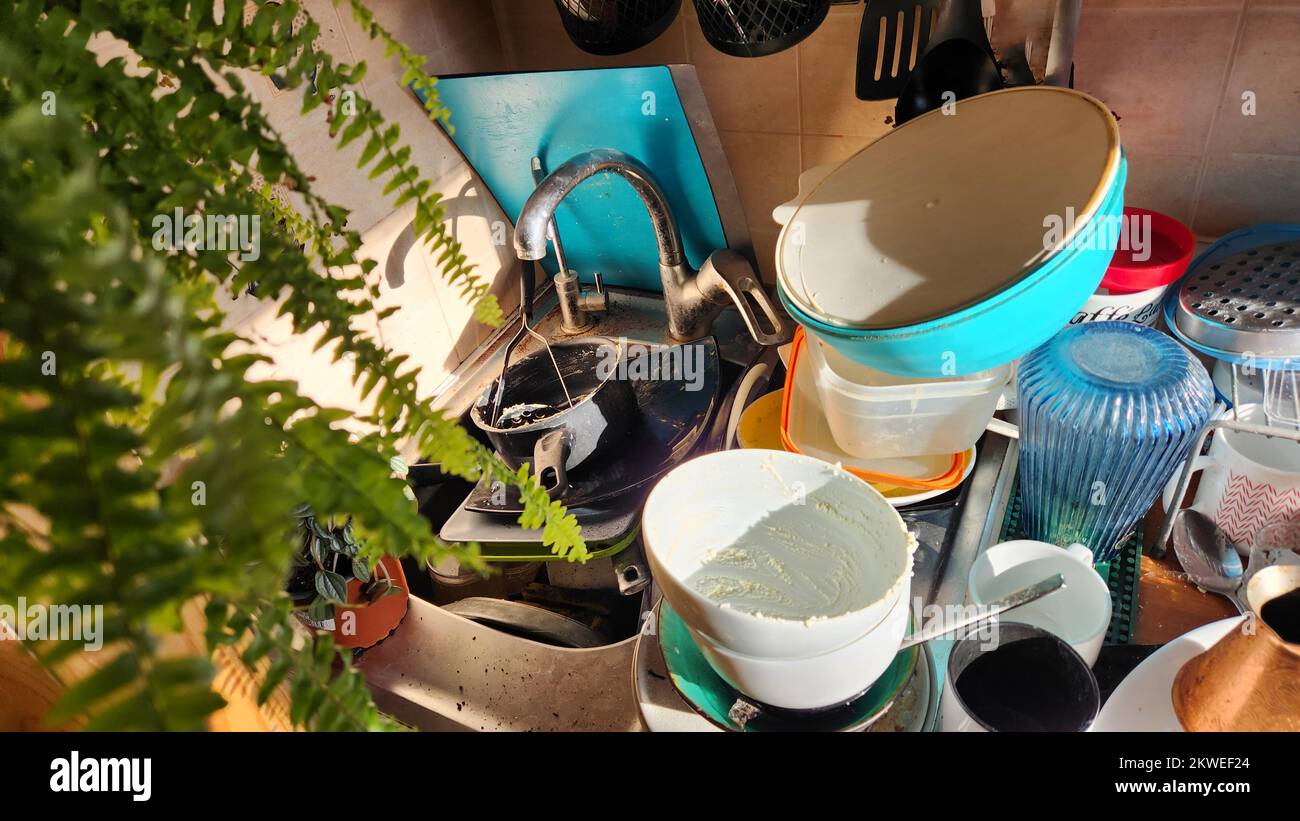 A mess in the kitchen. Dirty dishes around the sink. The concept of ...