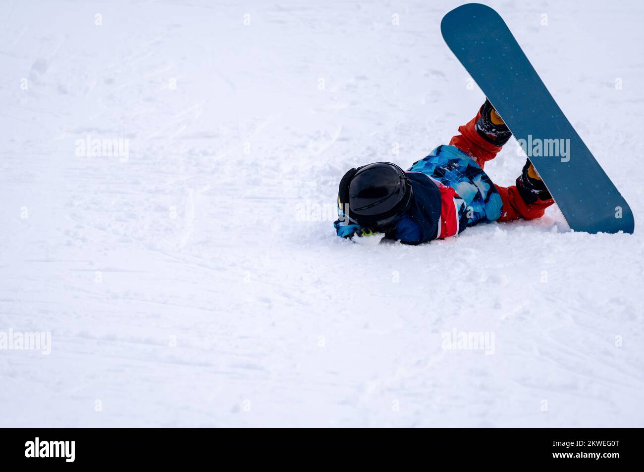 Person with snowboard on the snow. One Asian child is falling on the ...