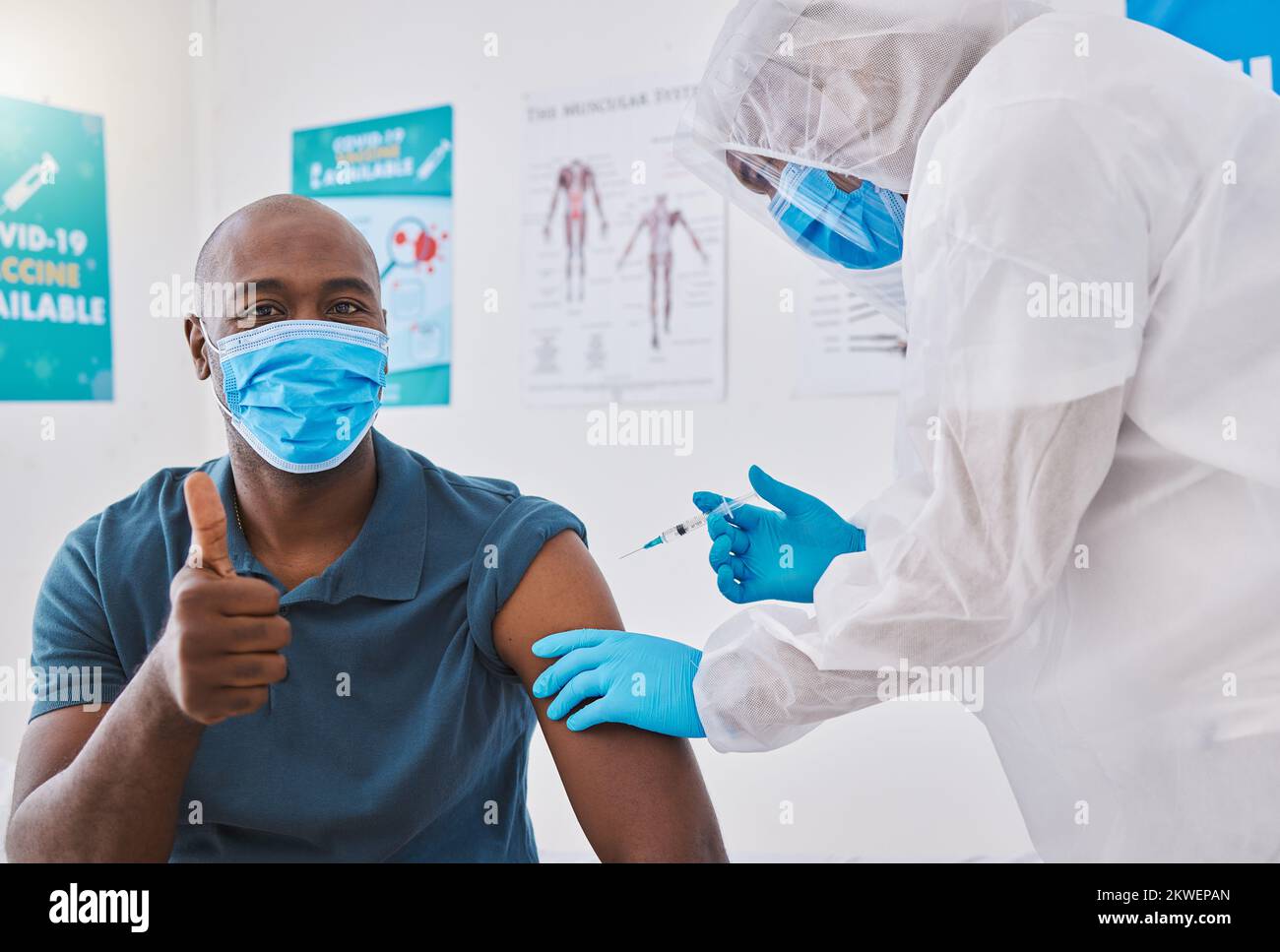 Thumbs up, vaccine and covid injection on a mans arm with him wearing a ...