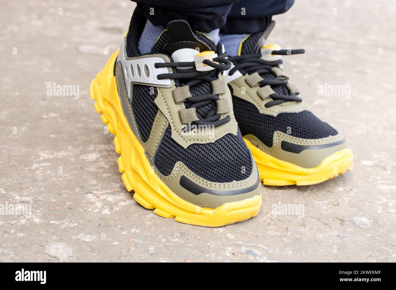Children's feet in stylish sneakers on a white background close-up ...
