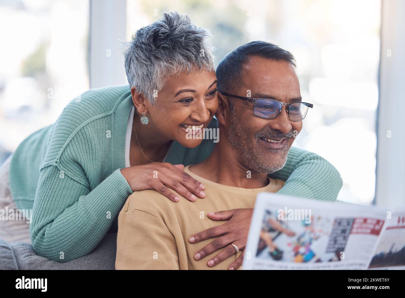 Love, senior couple and reading newspaper in living room of home ...