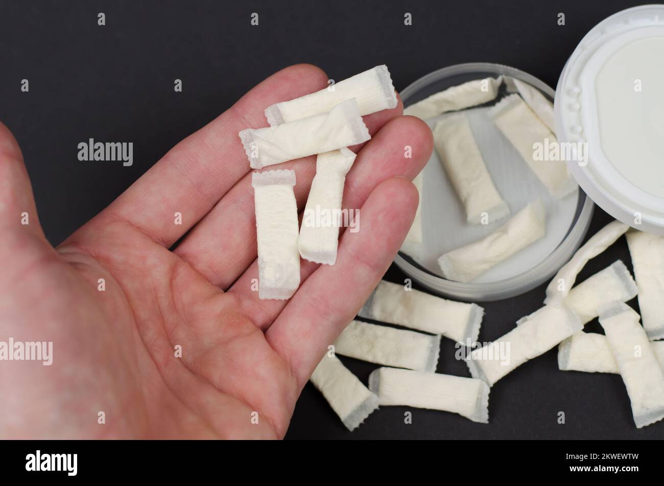 Sachets of Swedish snus in a man's hand on a black background Stock ...