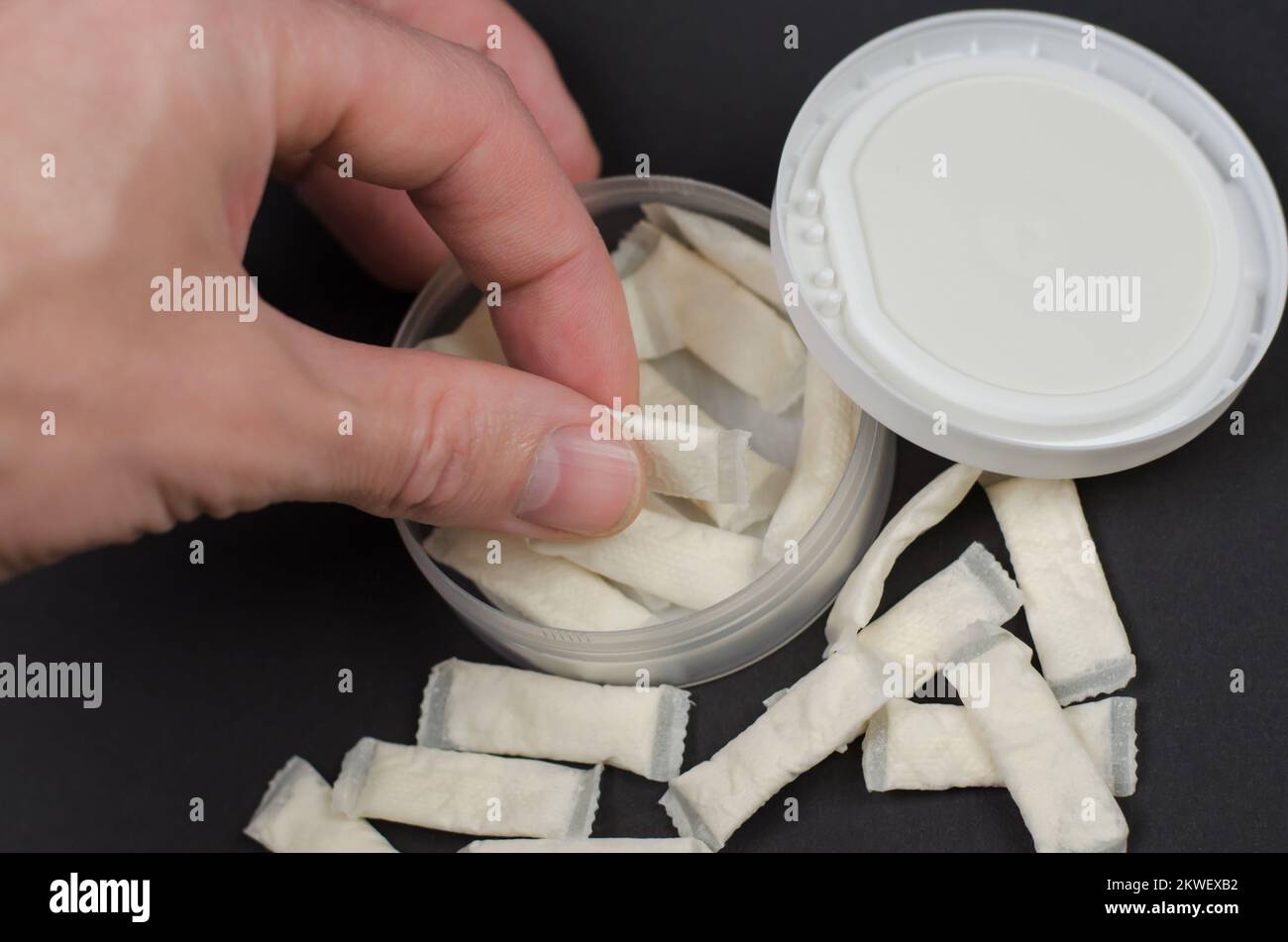 Man's hand takes a bag of Swedish snus on a black background Stock ...