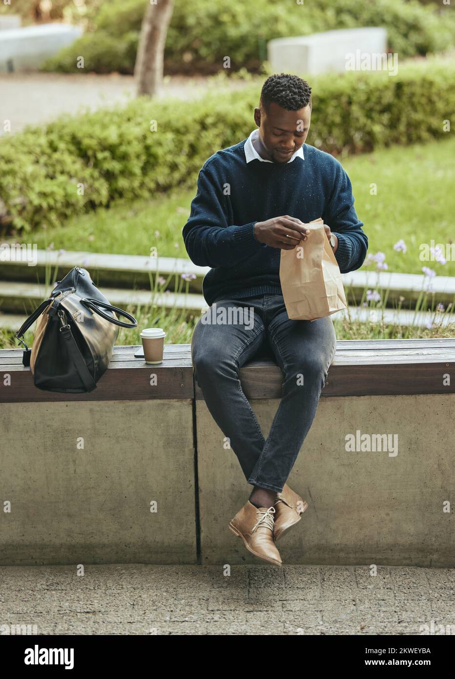 Business man eating food for lunch on his break outdoors at a park ...