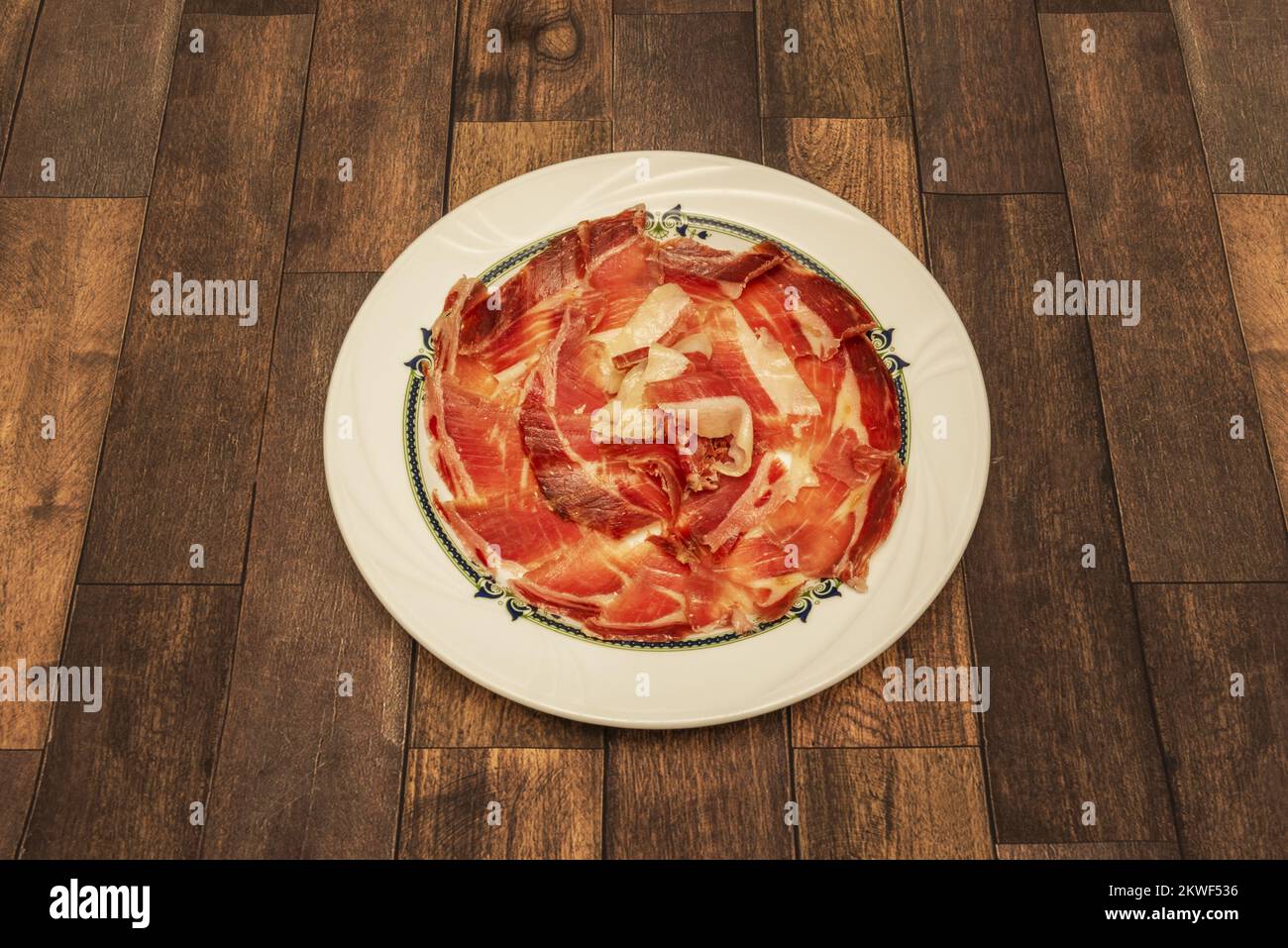 One of the most typical Spanish tapas, a plate of Iberian ham cut with ...