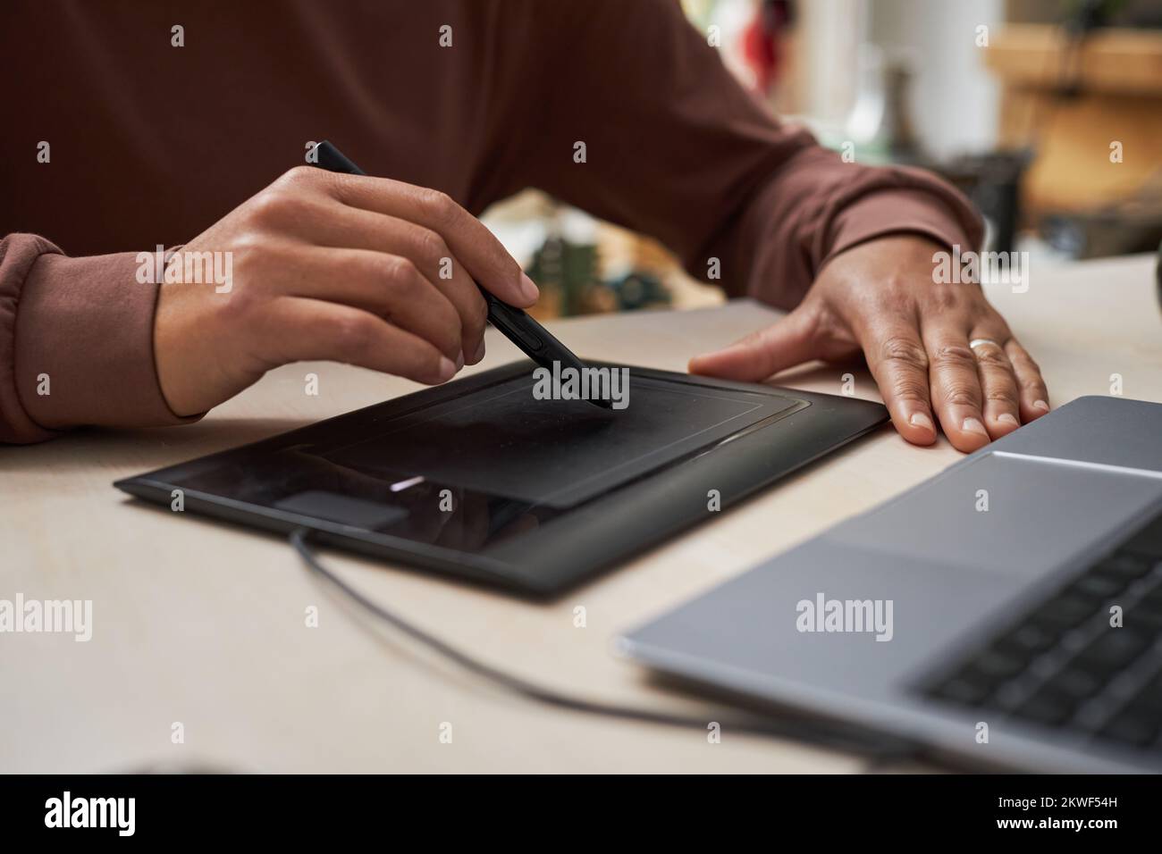 Close up of black female artist using graphic tablet with laptop while ...