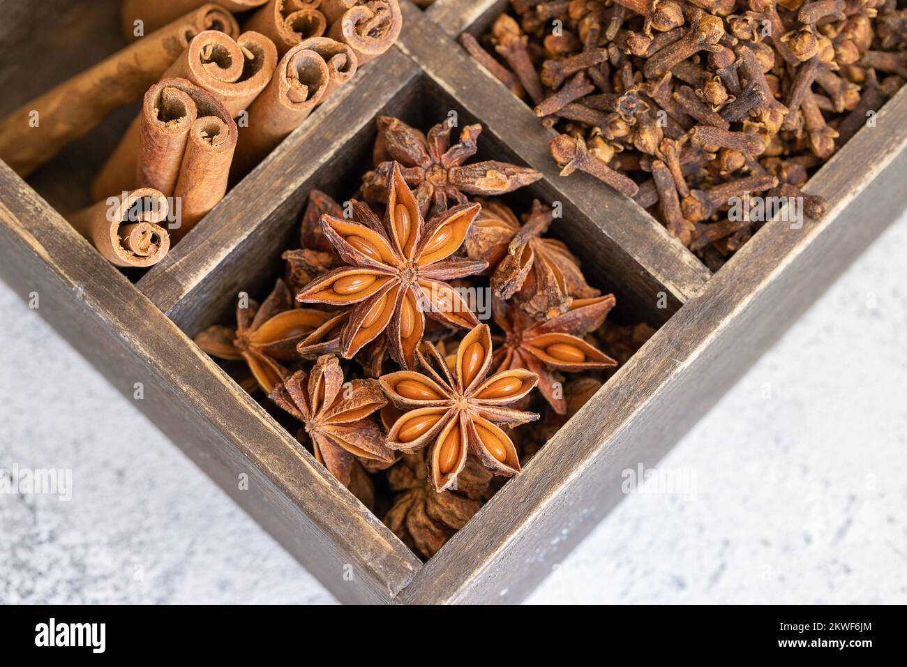 Different spices cinnamon, cloves and star anise on wooden box ...