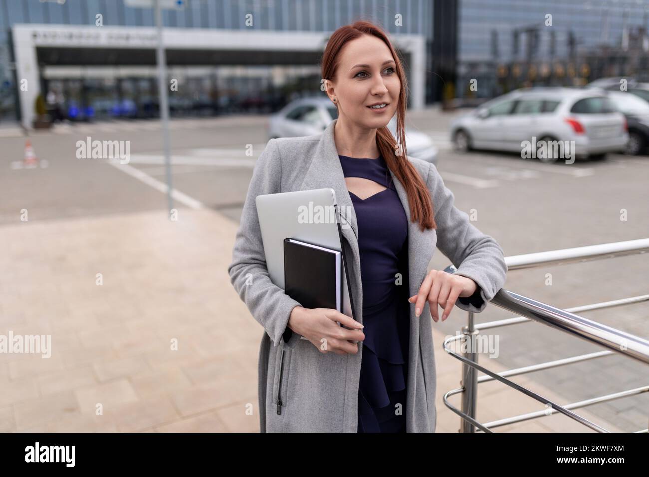 female insurance agent in the parking lot with a laptop looking into ...